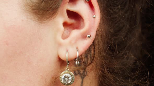 Human Ear with Earrings Closeup Blue Eyes Glitter on Low Eyelids ...