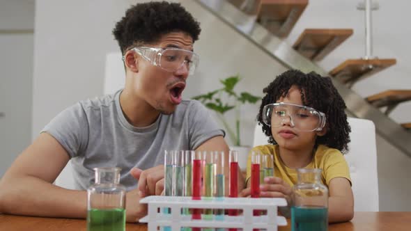 Happy biracial man and his son making chemistry experiments, Stock Footage