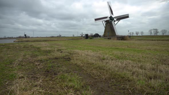 Dutch windmill turning fast in strong winds, camera tilt up reveal ...