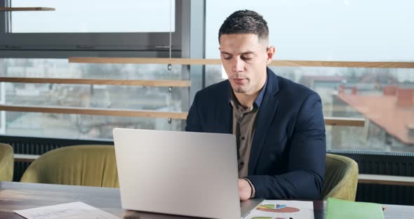 Concerned Man Working on Laptop Computer and Looking Away Thinking ...
