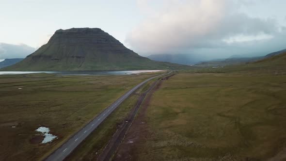 The world famous Mt. Kirkjufel in perspective next to the road. Slow ...