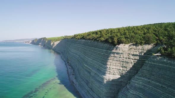 Aerial of High Steep Cliffs Covered with Pine Trees and Wild Pebble ...