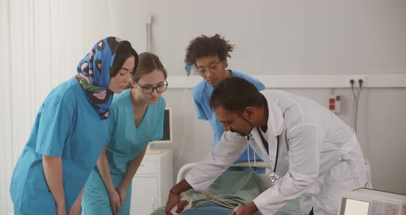 Doctor Using Defibrillator on Patient While Medical Team Standing ...