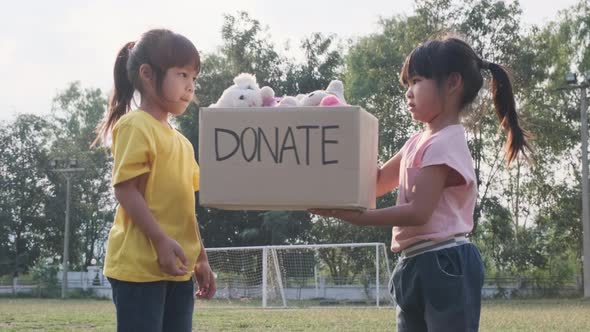 Young volunteers giving a donate box to the recipient in the park ...