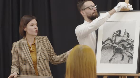 Female Auctioneer Pointing at Artwork and Speaking to Participants ...