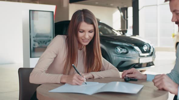 Lady Buying New Car Signing Papers With Dealer Man In Auto Dealership ...