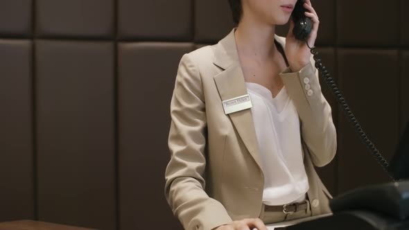 Receptionist Talking on Phone at Front Desk, Stock Footage | VideoHive
