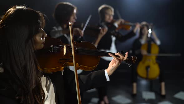 String Quartet Playing in a Room on the Floor Are Scattered Sheets with ...