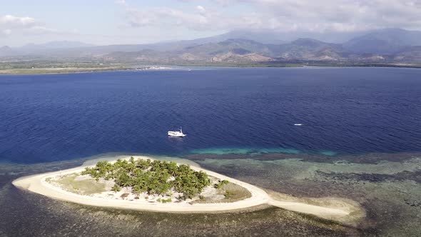 Tourist boat anchored next to Pulau Bedil, a tiny Indonesian beautiful ...