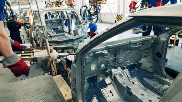 Car Factory Workers Welding a Vehicle Body at a Car Manufacturing ...