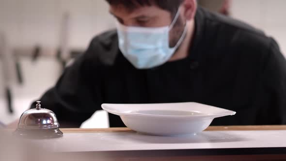 Chef with Medical Mask Serving a Dish in a Restaurant, Stock Footage
