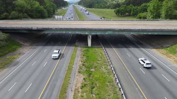 Vehicles passing under an overpass on a divided highway. Busy ...