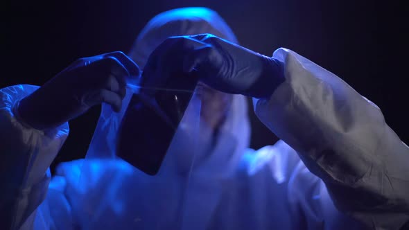 Criminalist Putting Cell Phone Into Transparent Package, Evidence at ...