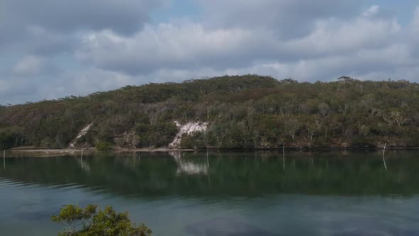 A large Australian billabong surrounded by rugged native bush and steep ...