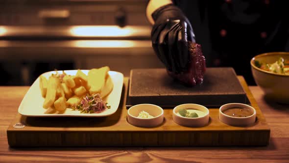 Cook preparing raw piece of meat on hot cooking stone, cinematic shot ...