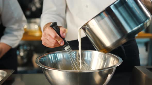 Milk is churned in a professional restaurant kitchen. Dessert cooking ...