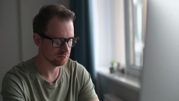 Concentrated Young Hipster Freelancer Man with Beard in Glasses Using ...