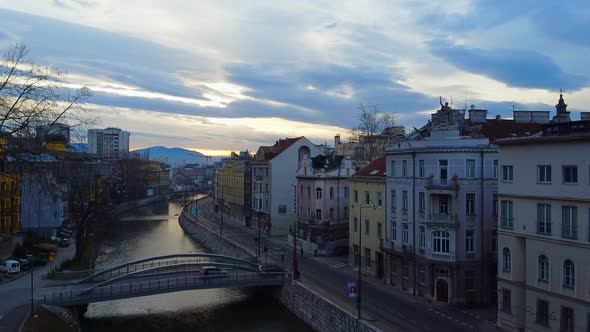Cityscape with Old Narrow Stone Bridge Over River at Dusk, Stock Footage