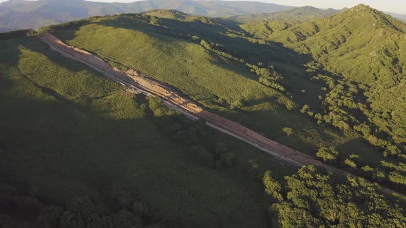 Laying the Main Gas Pipe in a Dug Trench Among the Mountains, Stock Footage