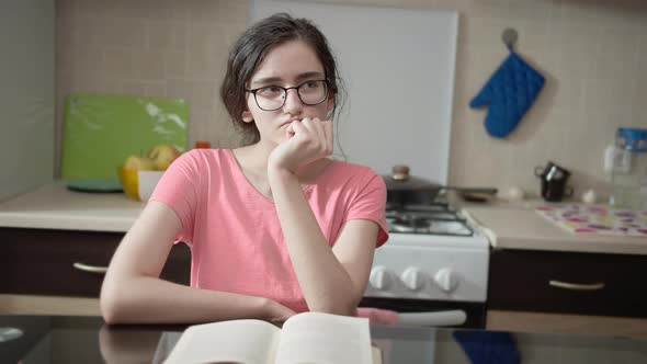 Girl Sitting Thinking at a Table in the Kitchen, Stock Footage | VideoHive