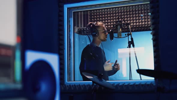 Male Rap Singer with Headphones and Sound Engineer are recording a new ...