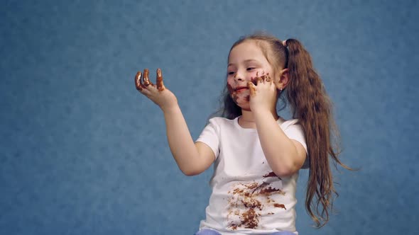 Portrait of girl with chocolate. Small girl with chocolate smeared all ...