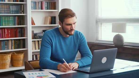 Young teacher taking notes in notebook using laptop, Stock Footage