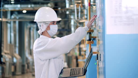 Factory Specialist is Operating a Laptop and a Cabinet Panel, Stock Footage
