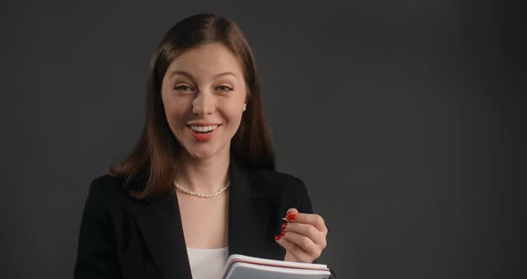 Young Woman in Black Suit Listens to the Collocutor with Smile and ...