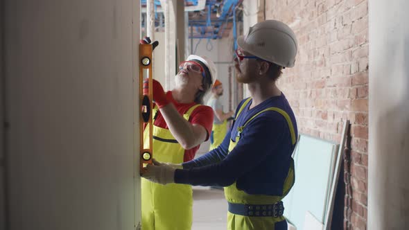 Builders with Level Tool Check Wall Surface Evenness, Stock Footage