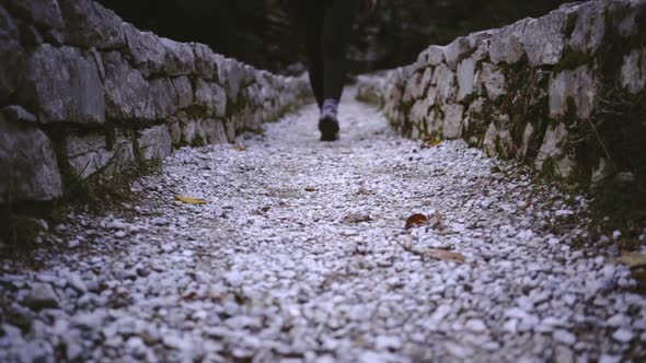 Anonymous woman walking on stone fence path, Stock Footage | VideoHive