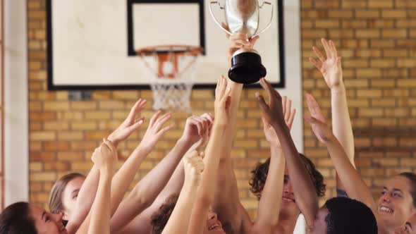 High school kids holding trophy in basketball court, Stock Footage