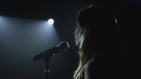 Closeup of the Face of the Singer with Microphone on a Black Smoky ...