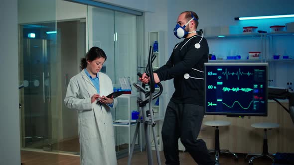 Sportsman with Mask Running on Cross Trainer in Sports Science ...
