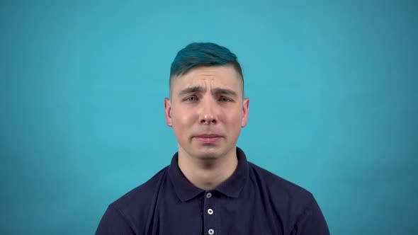 A Young Man in Glasses with Blue Hair Cries. Emotional Man Crying on a ...