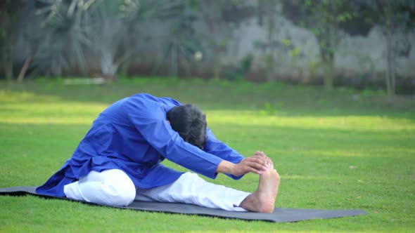 Indian man doing Folded Leg Forward Bend Yoga Pose or Triang Mukha Eka ...