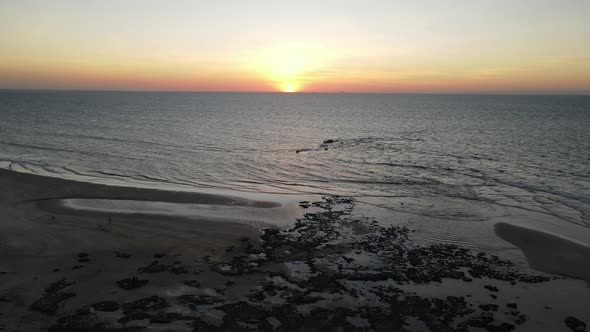 Slow moving drone shot of Orange sunset at Lee Point beach in Darwin ...