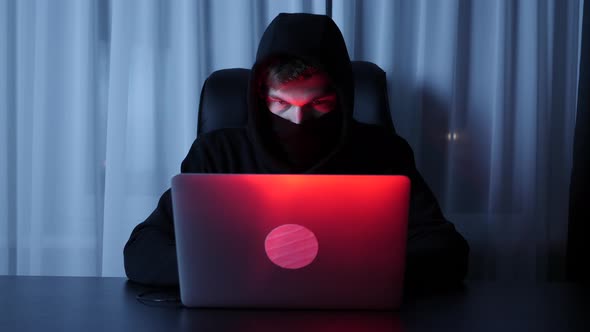 Man hacker face looking at computer screen in dark room. Cyber security ...