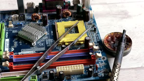 Soldering motherboard. Engineer solder a chipset under a magnifying ...