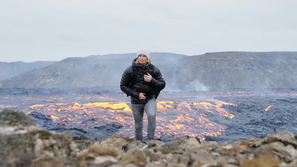 Man Taking Off Rucksack As Lava Flows Behind Him, Stock Footage | VideoHive