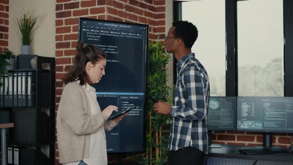 Software Developers Analyzing Source Code on Wall Screen Tv Comparing Errors Using Digital ...