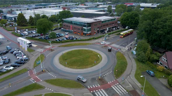 Aerial over busy roundabout and flying over industrial building with ...