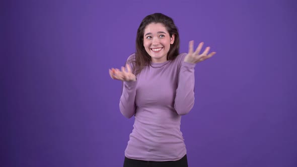 The Optimistic Young Woman with a Wide Smile Shrugs in Astonishment and ...