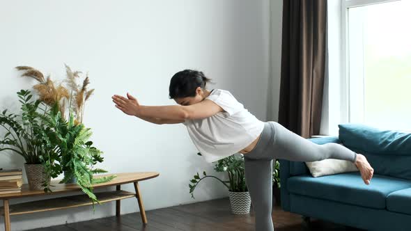 Woman in sportswear balancing on one leg while repeating asanas. Low ...