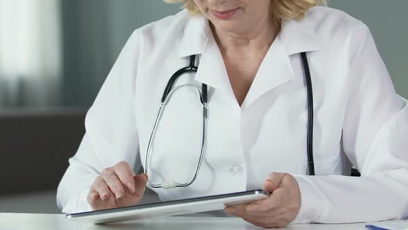 Female Therapist Scrolling Medical Documentation on Tablet, Modern ...