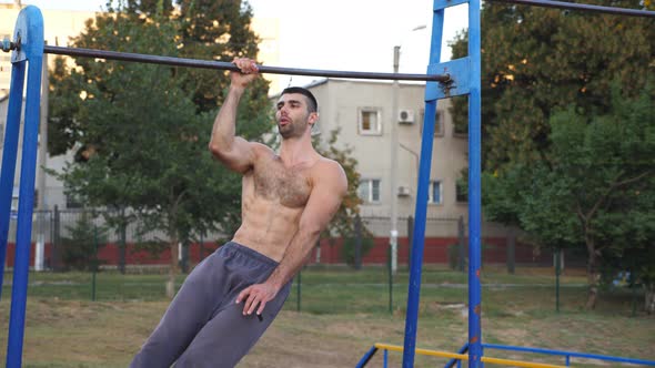 Sporty Man Doing One Hand Pull Ups at Sports Ground, Stock Footage