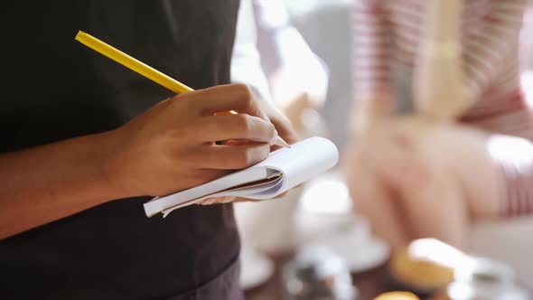 Waitress writing on notepad in restaurant, Stock Footage | VideoHive