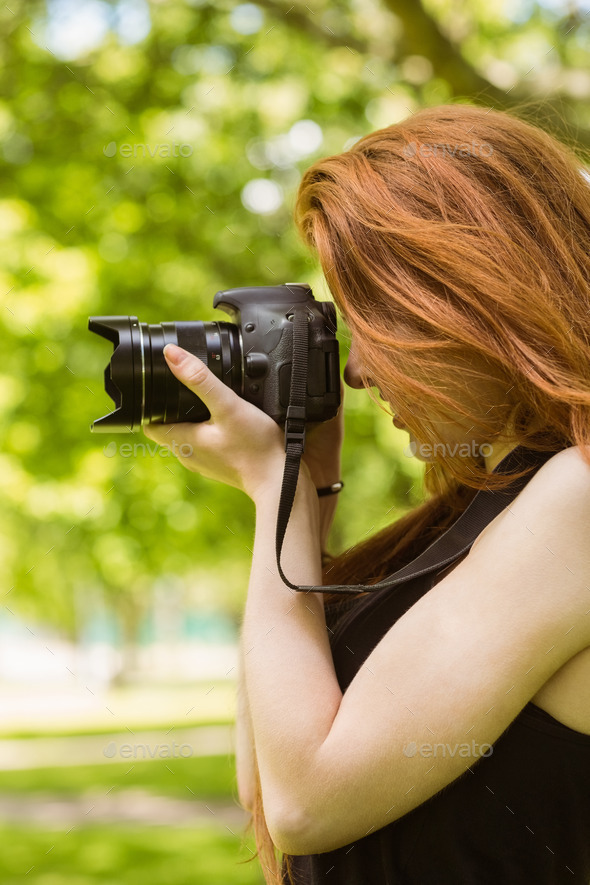 Side view of beautiful female photographer at the park Stock Photo by ...