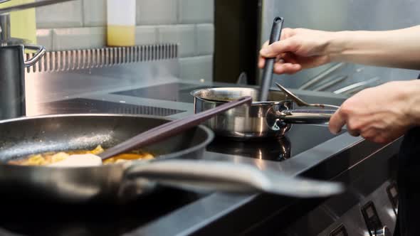 Chef Shakes a Saucepan on an Electric Stove and Mixing the Content ...
