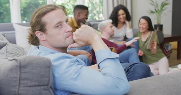 Smiling caucasian man sitting with diverse group of happy friends ...
